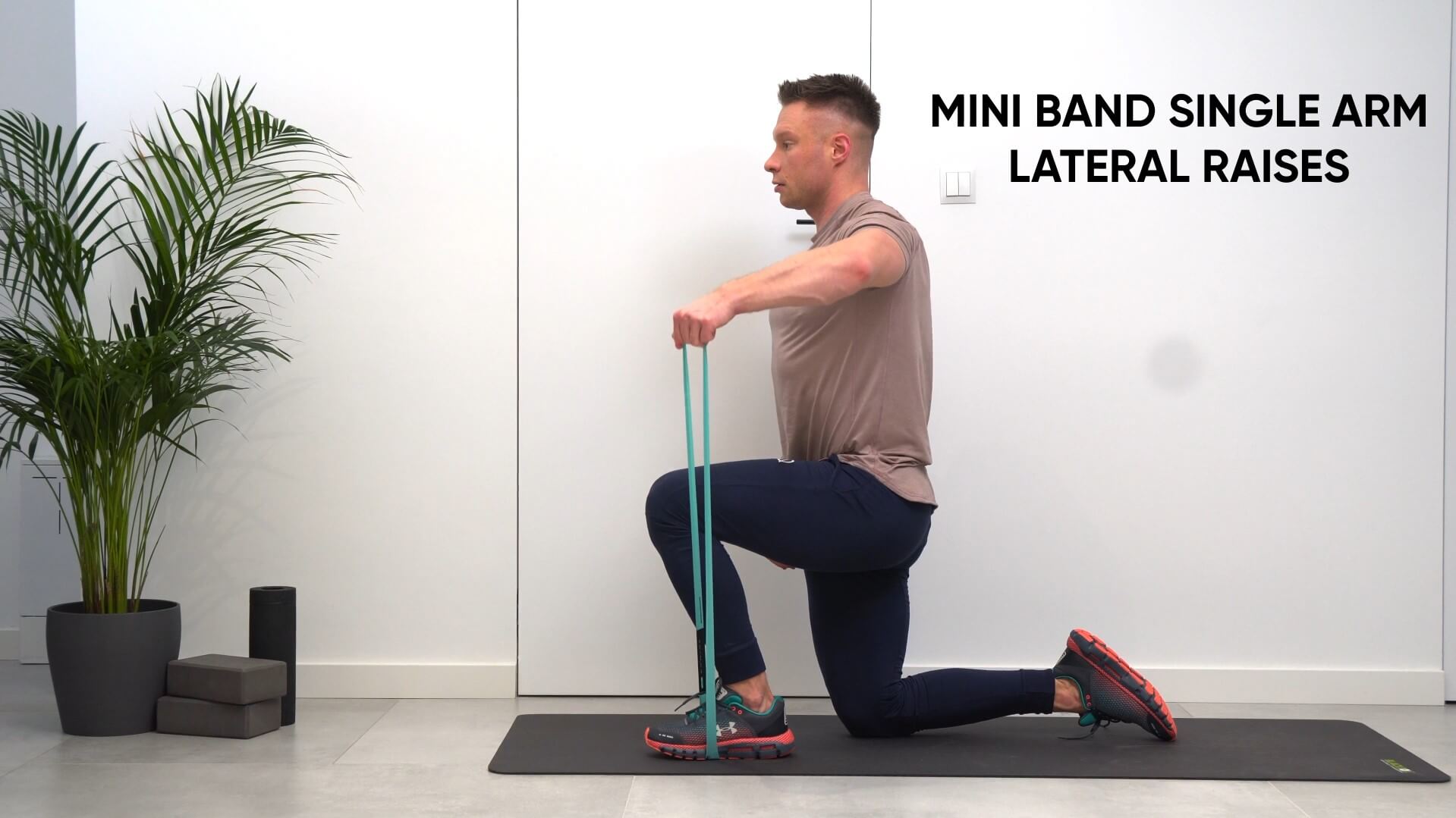 Mini band single arm lateral raises | Atlas ćwiczeń | Centrum Respo